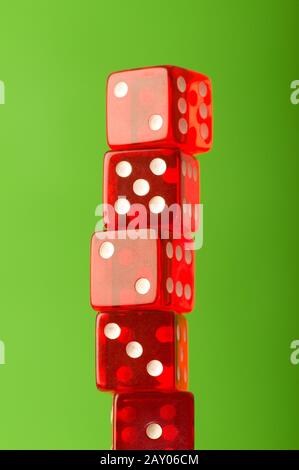 Red dice stack against blurred green background Stock Photo - Alamy