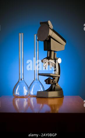 Microscope against blue gradient background Stock Photo - Alamy