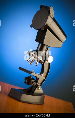 Microscope against blue gradient background Stock Photo - Alamy
