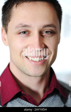 Closeup portrait of young slightly smiling Caucasian man in the city ...