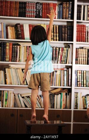 Boy trying to reach shelf in wardrobe Stock Photo - Alamy