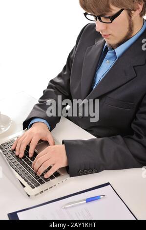 Young businessman working on his laptop seated at table Stock Photo - Alamy