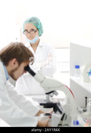 Two young Laboratory scientists working at lab with test tubes and ...