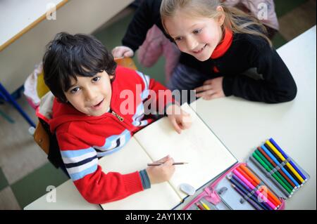 Portrait of lovely girl drawing with classmates on background Stock ...