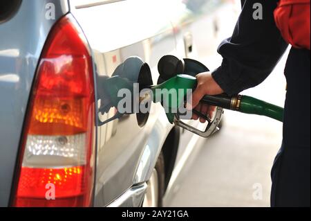 man hand refilling up gas tank of the car with green eco fuel on a ...