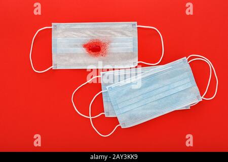 Hemoptysis, coronavirus, protective surgical mask with blood on red ...