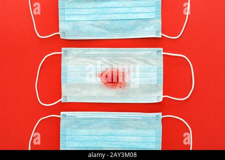 Hemoptysis, coronavirus, protective surgical mask with blood on red ...