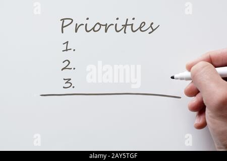 Priorities written on whiteboard Stock Photo - Alamy