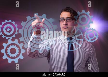 The teamwork concept with businessman and cogwheels Stock Photo - Alamy