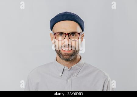 Headshot of handsome unshaven man wears transparent glasses, headgear ...