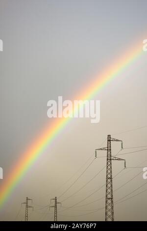 Rainbow through power line Stock Photo - Alamy