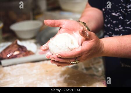 Female hands prepare a classic Caucasian khychin dish in the kitchen in ...
