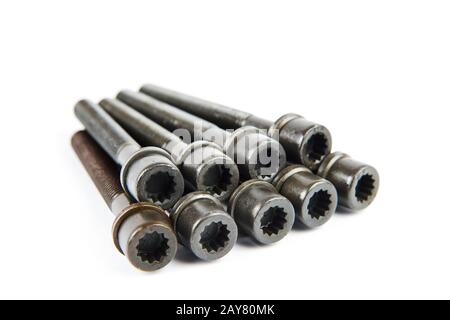 A set of new cylinder head bolts in oil on a white isolated background ...