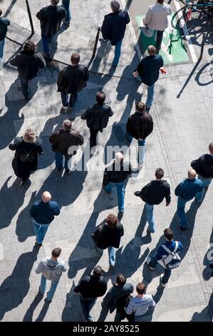 Pedestrians on crowded pavement walking under bamboo scaffolding and ...
