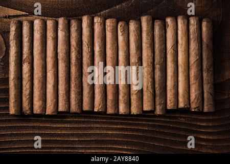Cuban cigars on rustic wooden table in line on the edge of background ...