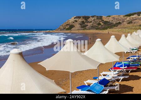 A line of umbrellas and sunbeds in Davlos beach, island of Cyprus Stock ...