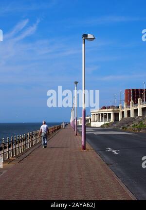 Man walking at seaside walkway with seafront view of Jumeirah beach ...