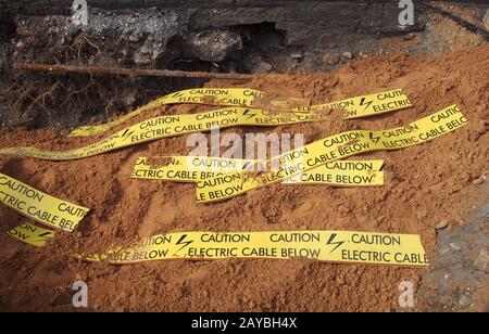 Underground electric cable with safety tape laid over the top to show ...