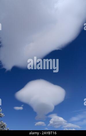 Lenticular circular clouds over the blue sky Stock Photo - Alamy