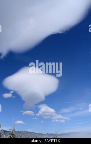 Lenticular circular clouds over the blue sky Stock Photo - Alamy