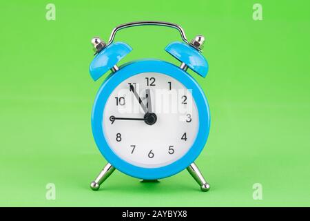 Classic alarm clock on a green background Stock Photo - Alamy