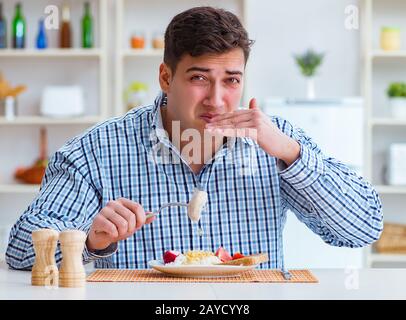 Man eating tasteless food at home for lunch Stock Photo - Alamy