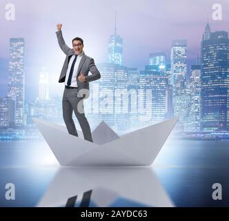 Businessman riding paper boat in dollar sea Stock Photo - Alamy