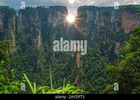 Sun shining through the vertical karst pillar rock formations as seen ...