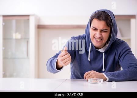 The young man having problems with narcotics at home Stock Photo - Alamy