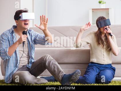 The pair singing karaoke with virtual reality glasses Stock Photo - Alamy