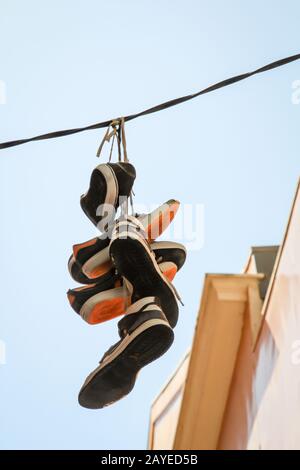 several shoes were thrown up and got caught on a power line Stock Photo ...