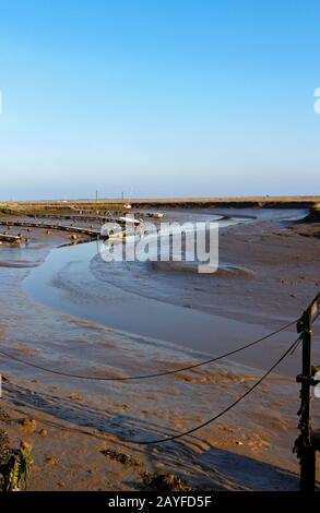 A view of the tidal channel through salt marshes towards the sea at ebb ...