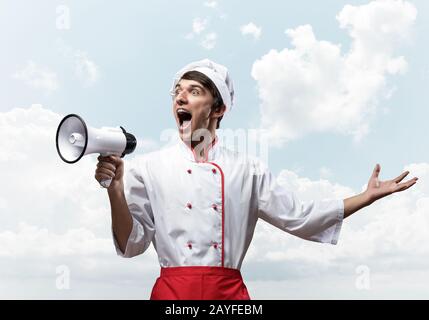 Young chef shouting loudly into megaphone Stock Photo - Alamy
