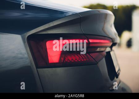 Detail of red metallized black rear car headlight in eye shape, with ...