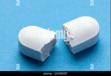 Pill broken on half. Pharmacy medicament concept. a white round tablet ...