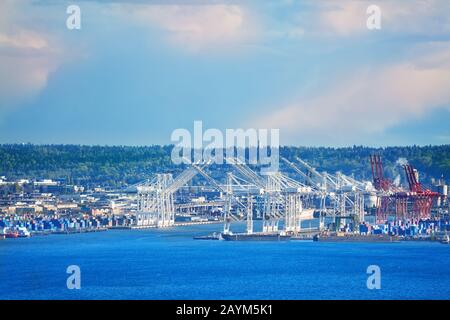 WA, Seattle, Seattle skyline with shipping cranes from Elliott Bay ...