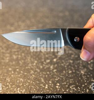 Symbole, Symbolbild, Eine Faust haelt ein Messer in der Hand Stock ...