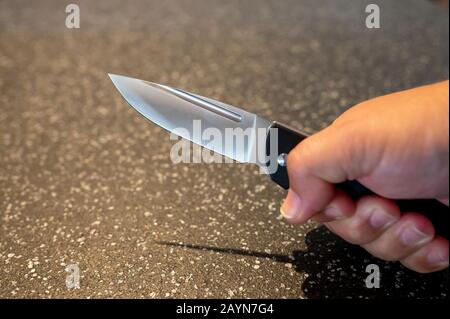 Symbole, Symbolbild, Eine Faust haelt ein Messer in der Hand Stock ...