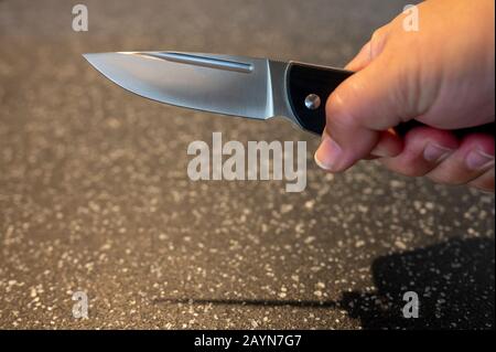 Symbole, Symbolbild, Eine Faust haelt ein Messer in der Hand Stock ...