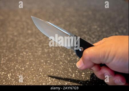 Symbole, Symbolbild, Eine Faust haelt ein Messer in der Hand Stock ...