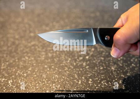 Symbole, Symbolbild, Eine Faust haelt ein Messer in der Hand Stock ...