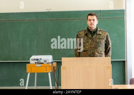 German soldier stands in a classroom . German word Bundeswehr, means ...