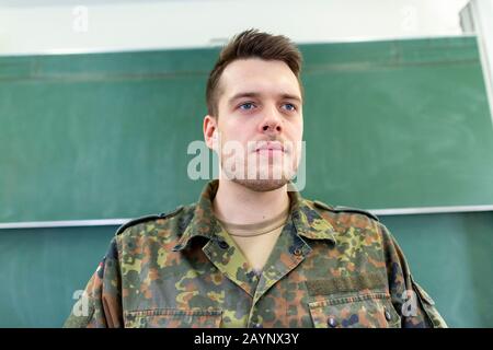 German soldier stands in a classroom . German word Bundeswehr, means ...