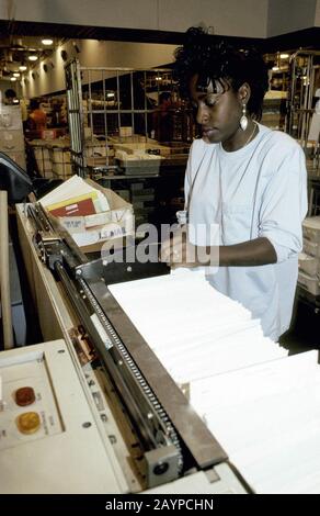 Female United States Postal Service carrier delivering mail in ...