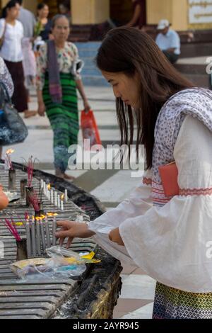 Young woman lighting candles in Our Lady of Lebanon sanctuary, Harissa ...