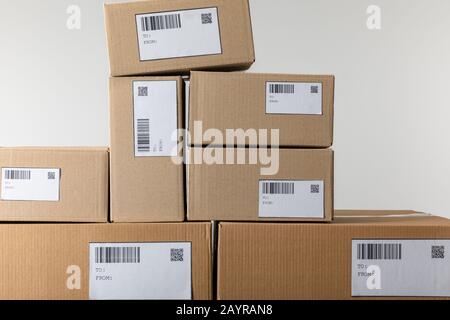 Stacked cardboard boxes with barcodes and qr codes isolated on grey ...