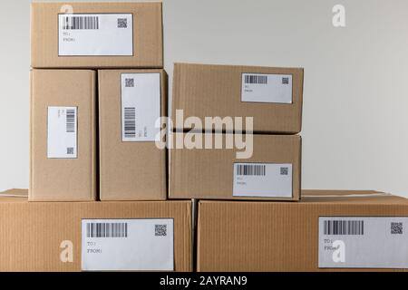 Stacked cardboard boxes with qr and barcodes on cards isolated on blue ...