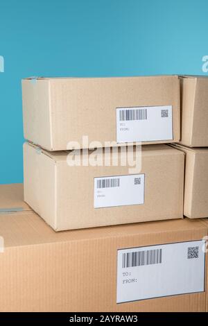 Stacked cardboard boxes with qr and barcodes on cards isolated on blue ...