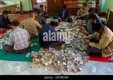 Men counting money donated to at the Gubyaukgyi Temple, Bagan, Myanmar ...
