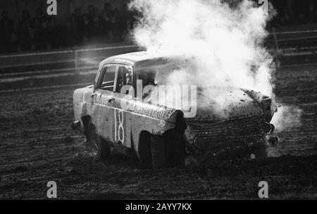1970s, historical, a banger racing car with smoke pouring out from a ...